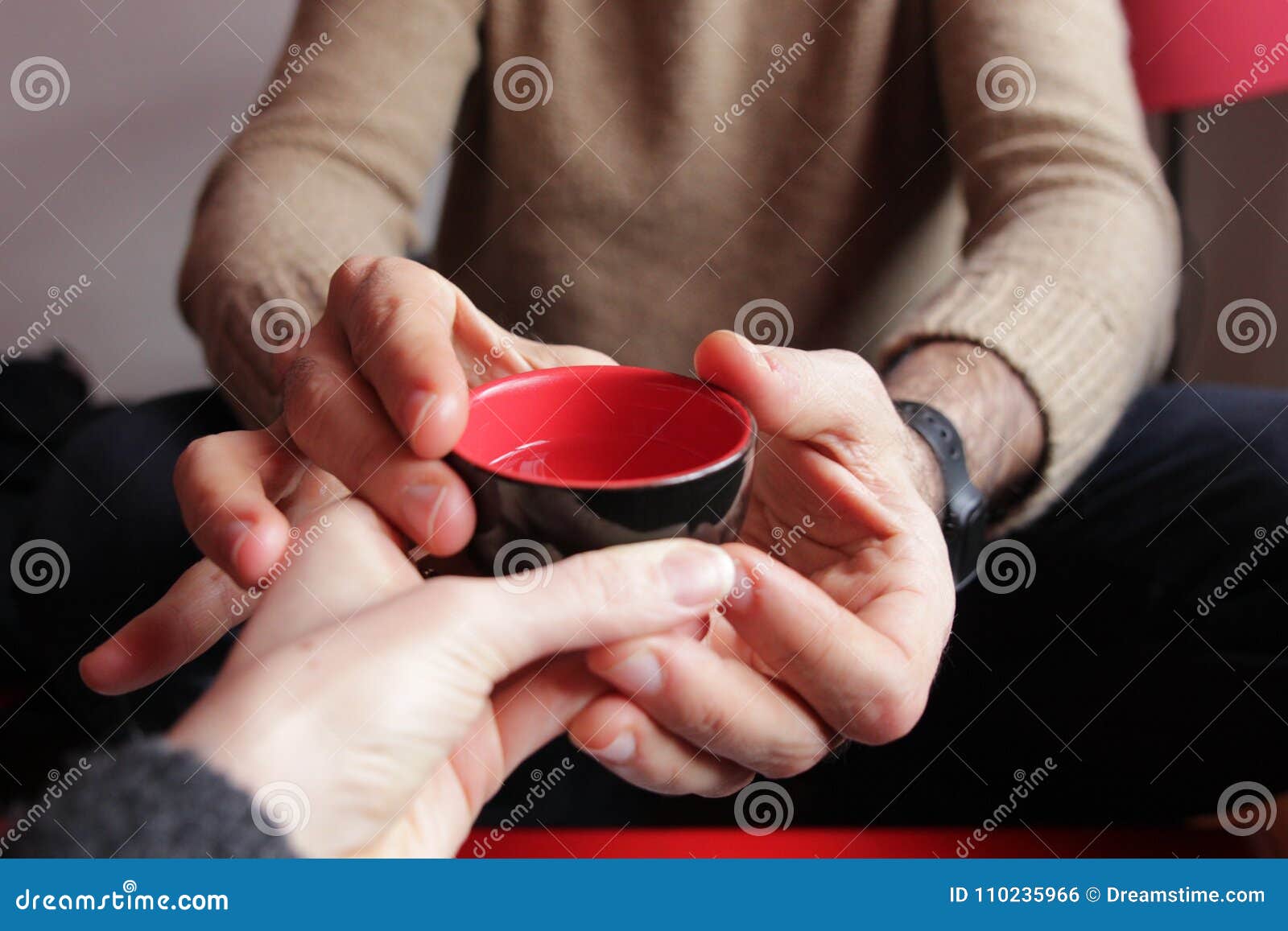 Couple sharing a tea cup stock photo. Image of hands - 110235966