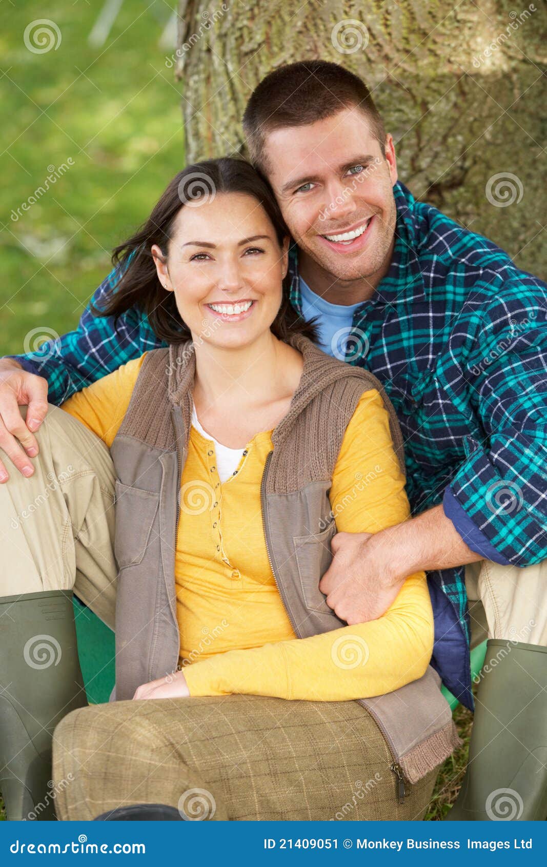 Couple Sitting Against Tree Trunk Stock Image - Image of enjoying ...