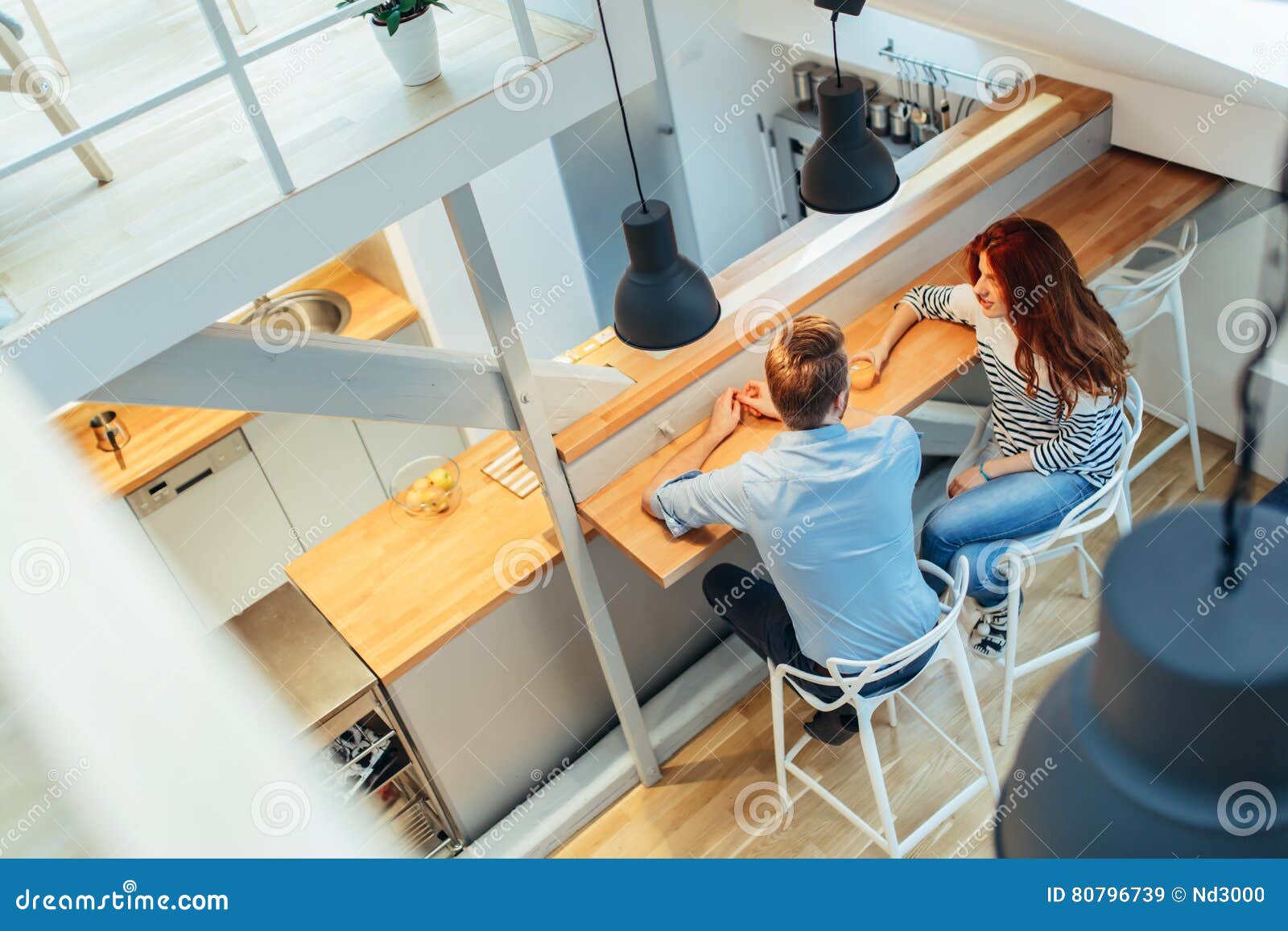 Couple Sitting at Counter in Decorative Home Stock Image - Image of ...