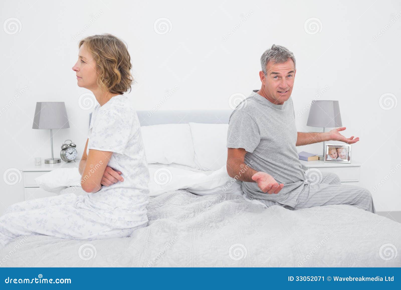 Couple Sitting On Different Sides Of Bed Having A Dispute Stock Image