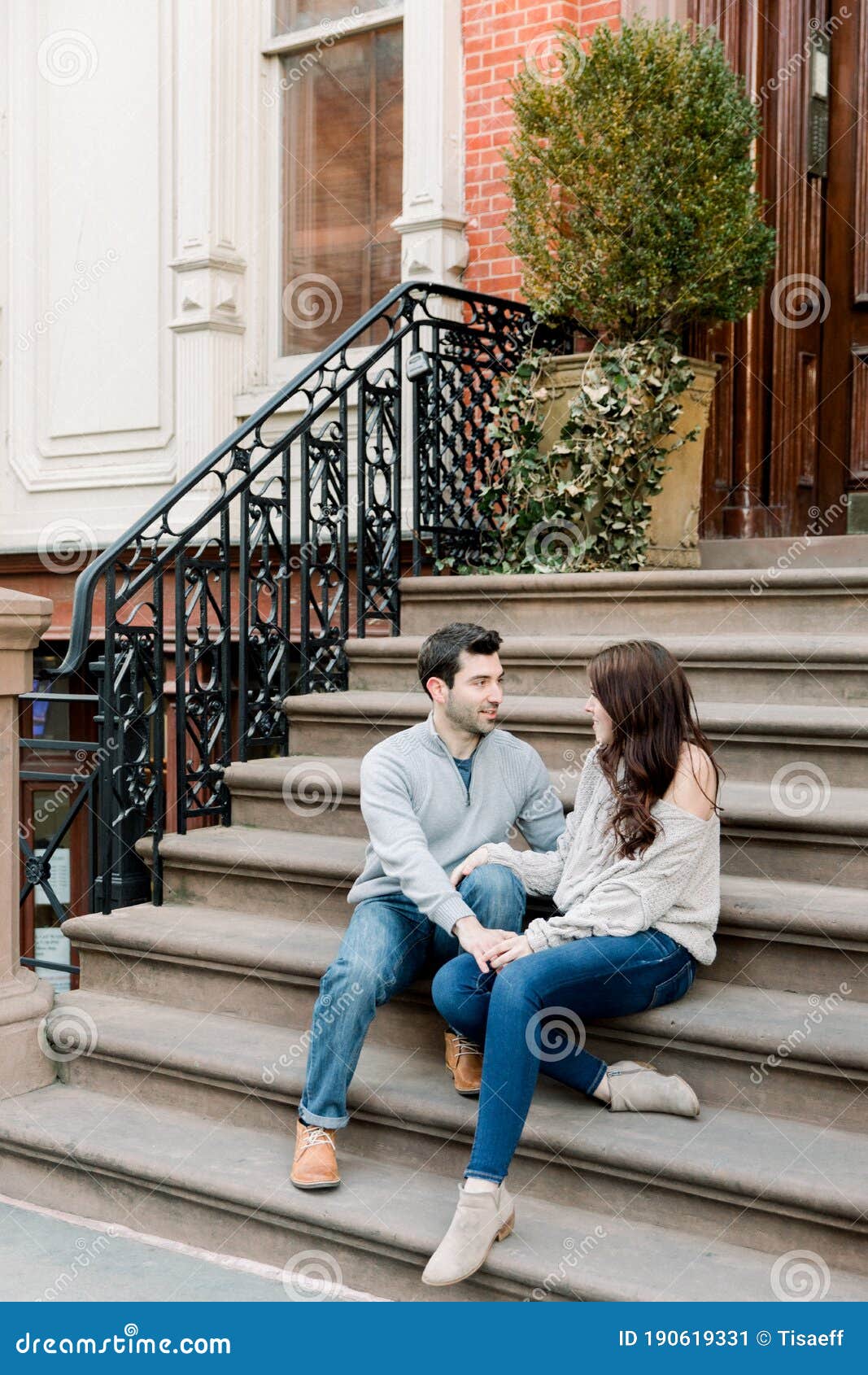 A Young Couple Sitting on a Stoop and Casually Chatting Stock Image ...