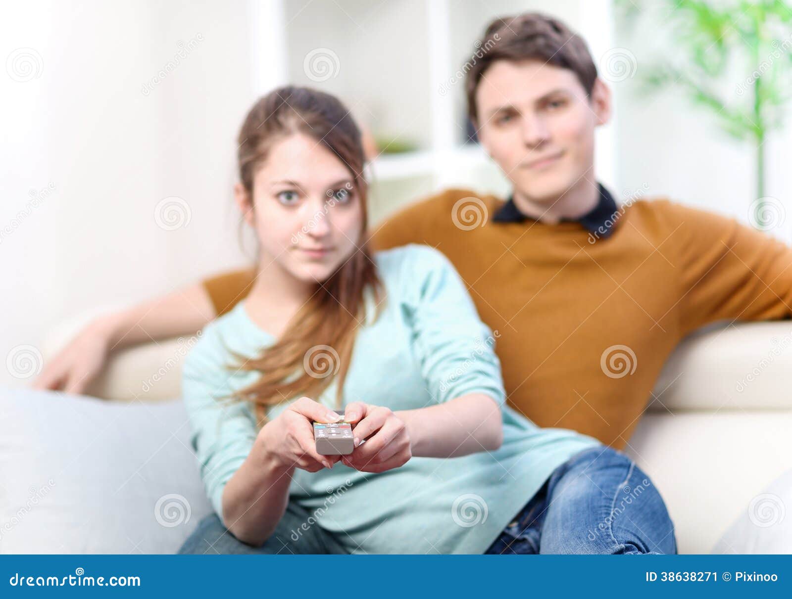 Couple Sitting in Sofa with Remote Control in Hands Stock Image - Image ...