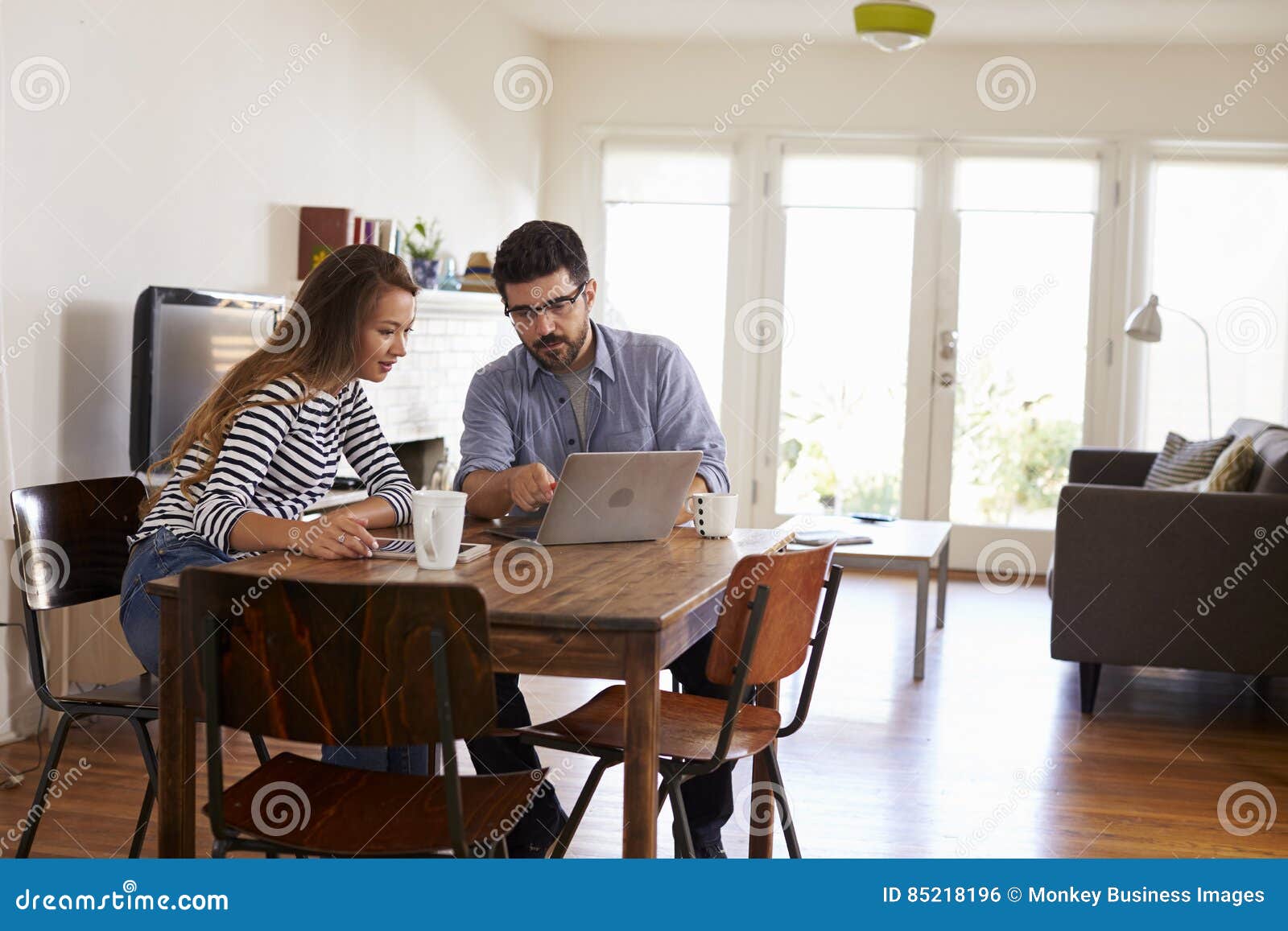 Couple Sitting at Table Using Laptop Together Stock Photo - Image of ...