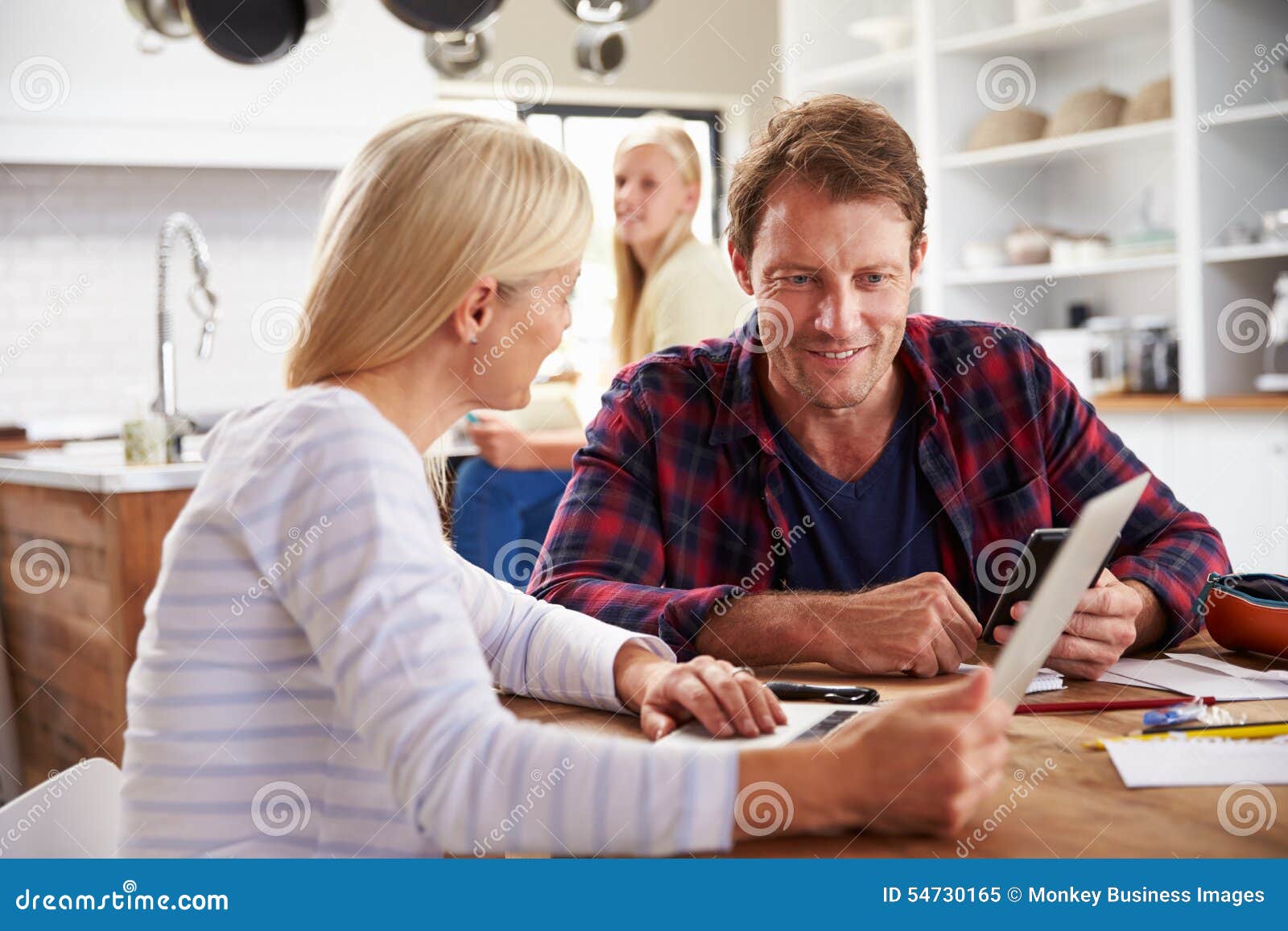 Couple Sitting in Their Kitchen Using Computers Stock Image - Image of ...