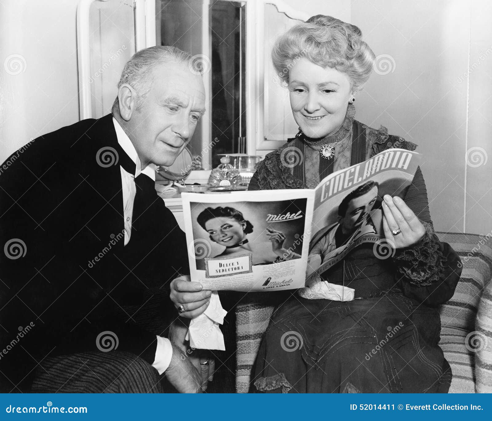 Couple Sitting Together and Looking at a Magazine Stock Image - Image ...