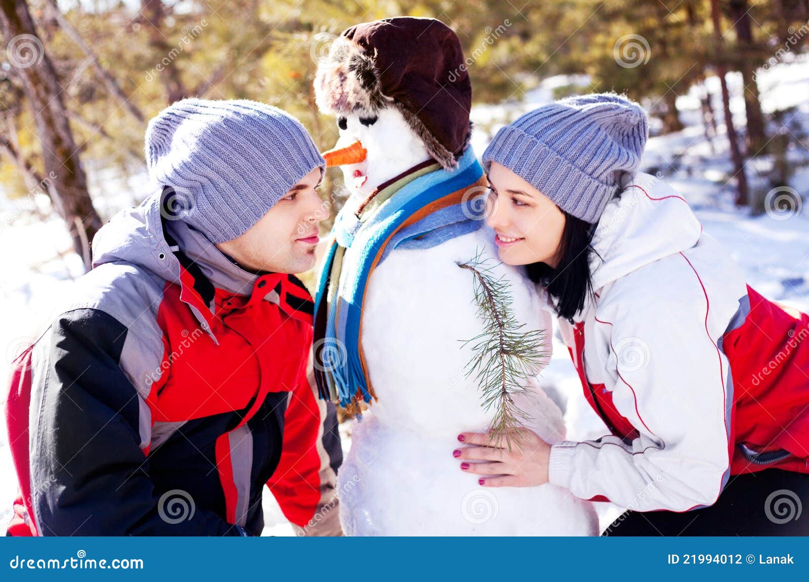 Couple with a snowman stock photo. Image of embrace, casual - 21994012
