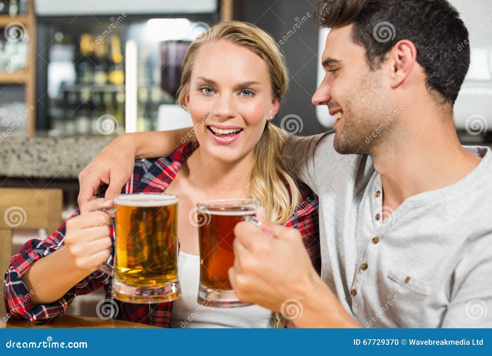 Couple toasting with beers stock photo. Image of people - 67729370