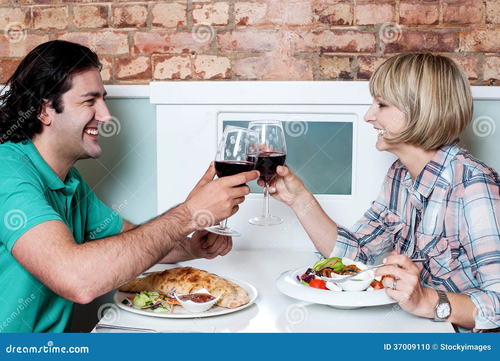 Couple Toasting Over a Restaurant Table Stock Photo - Image of female ...