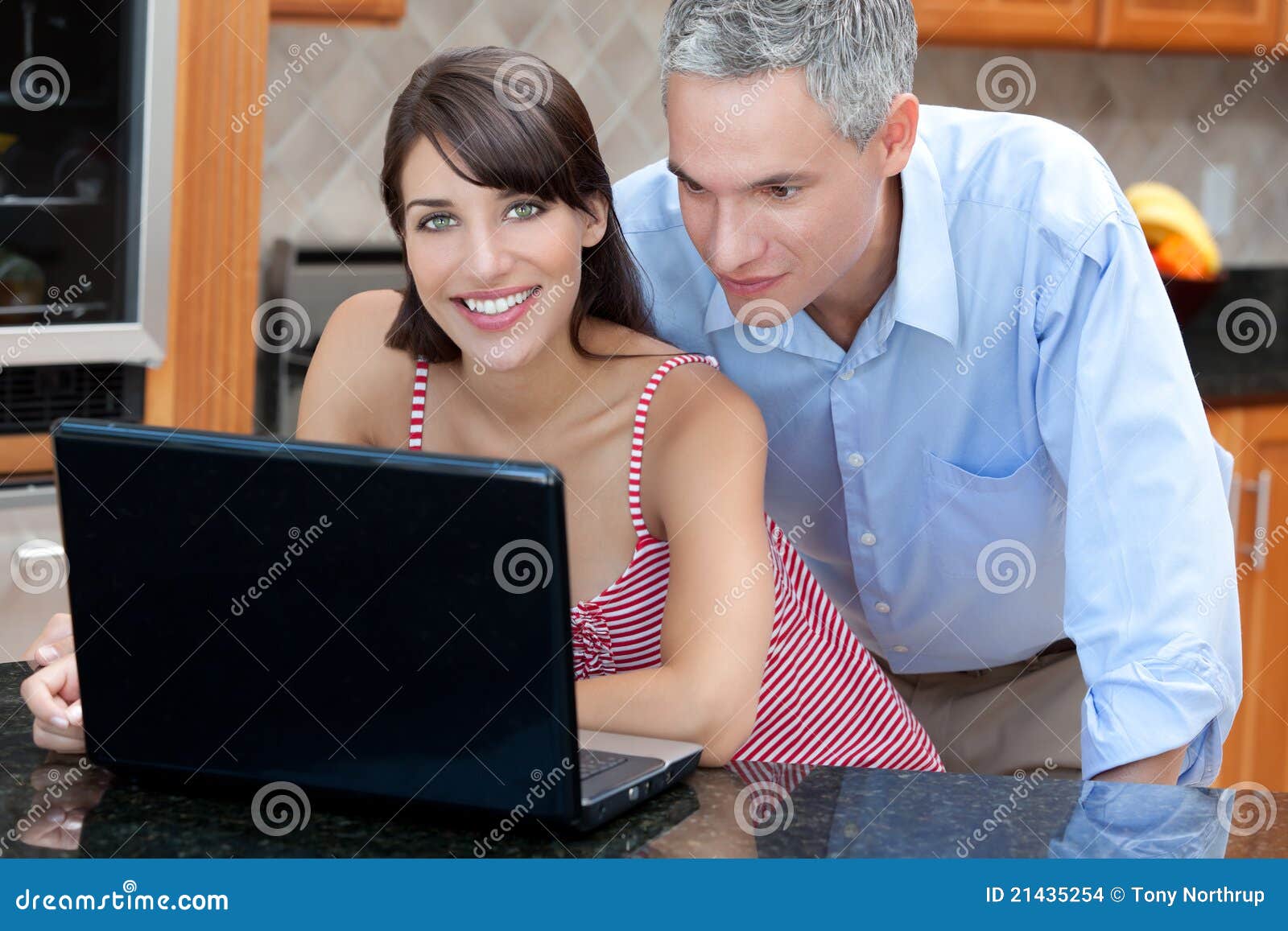 Couple Using Laptop Computer in Kitchen Stock Photo - Image of girl ...