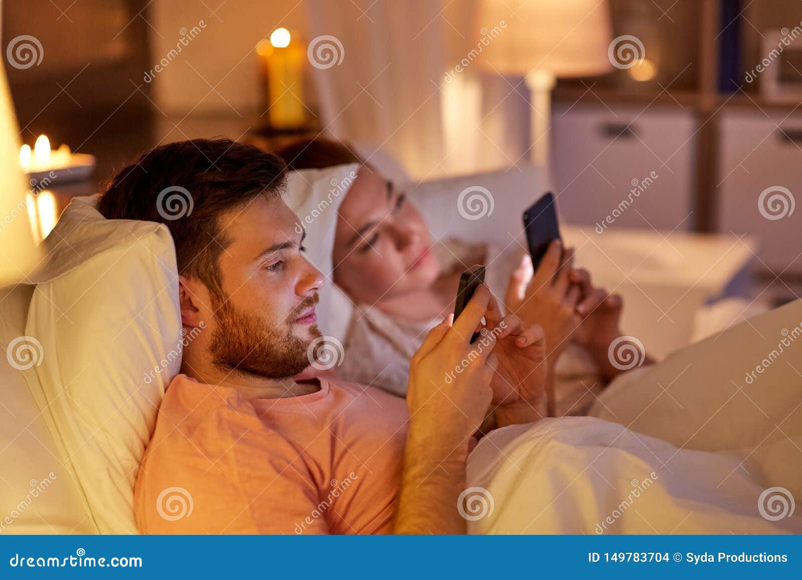 Couple Using Smartphones in Bed at Night Stock Photo - Image of ...