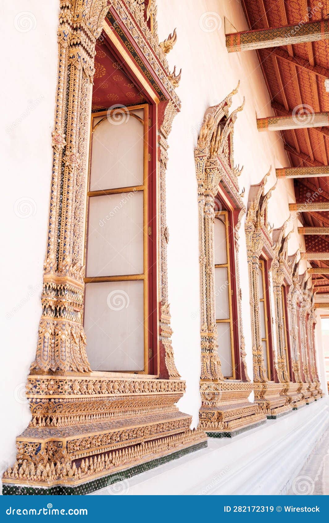 A Couple Walks through a Corridor Next To Large Windows and a White ...