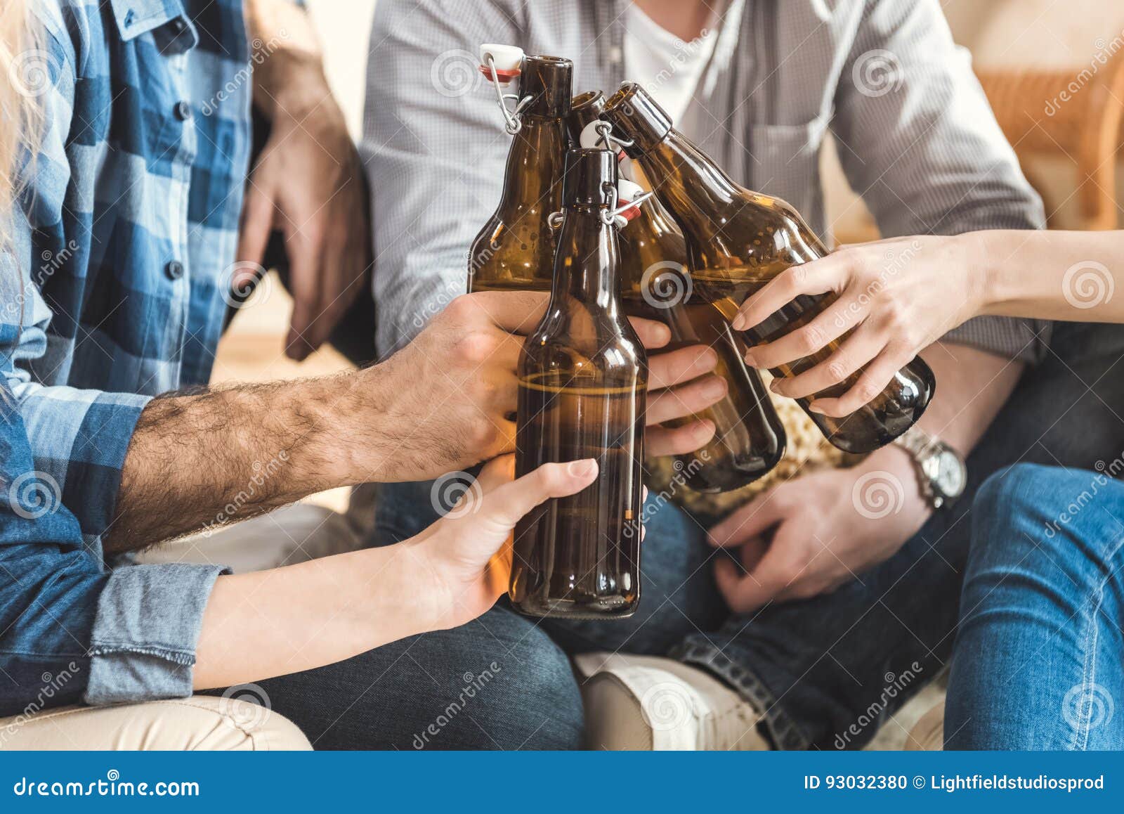 Couples Clinking Beer Bottles Stock Photo - Image of sitting ...