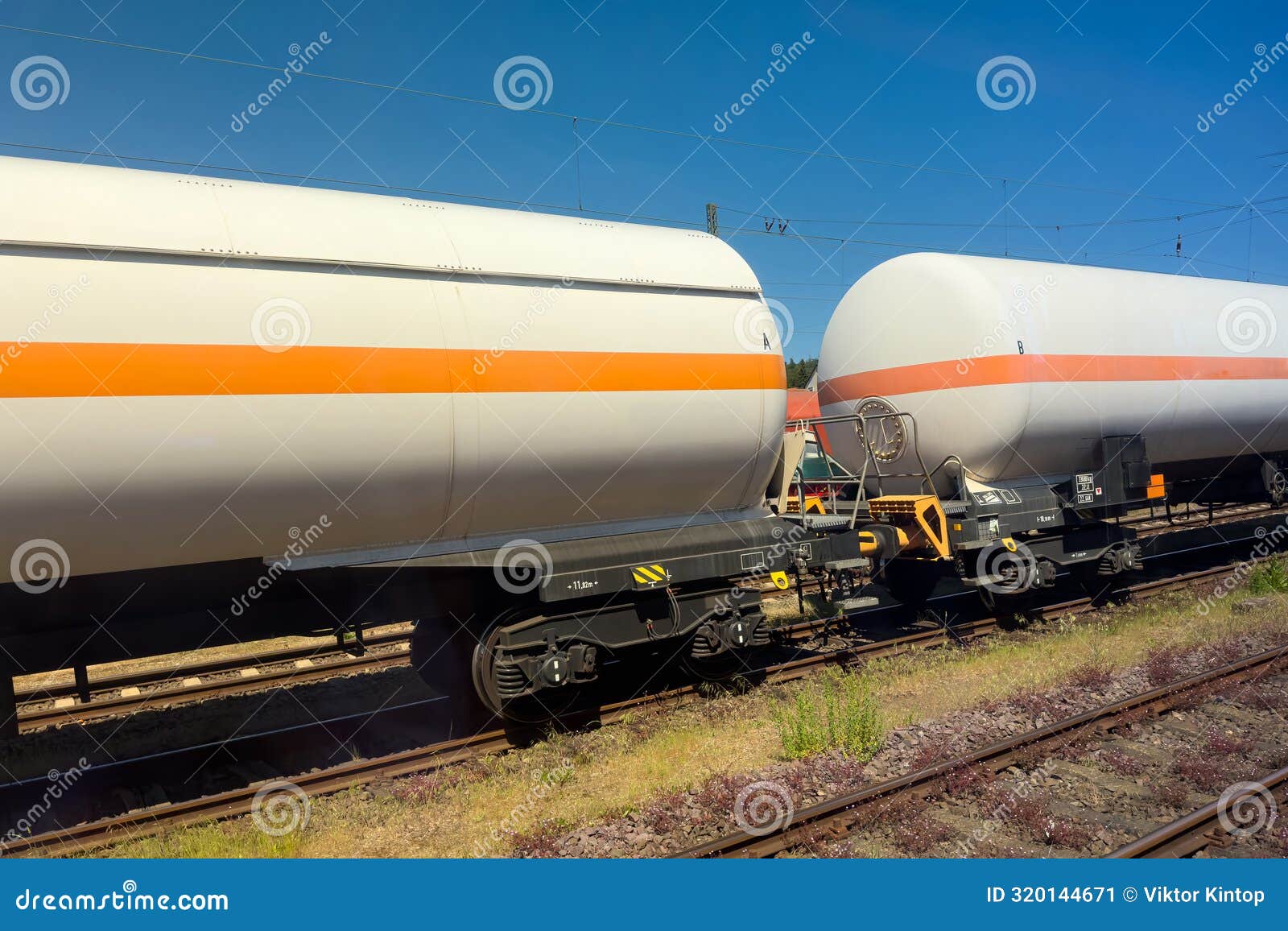 A Coupling of Two White Railway Tanks with a Longitudinal Orange Stripe ...