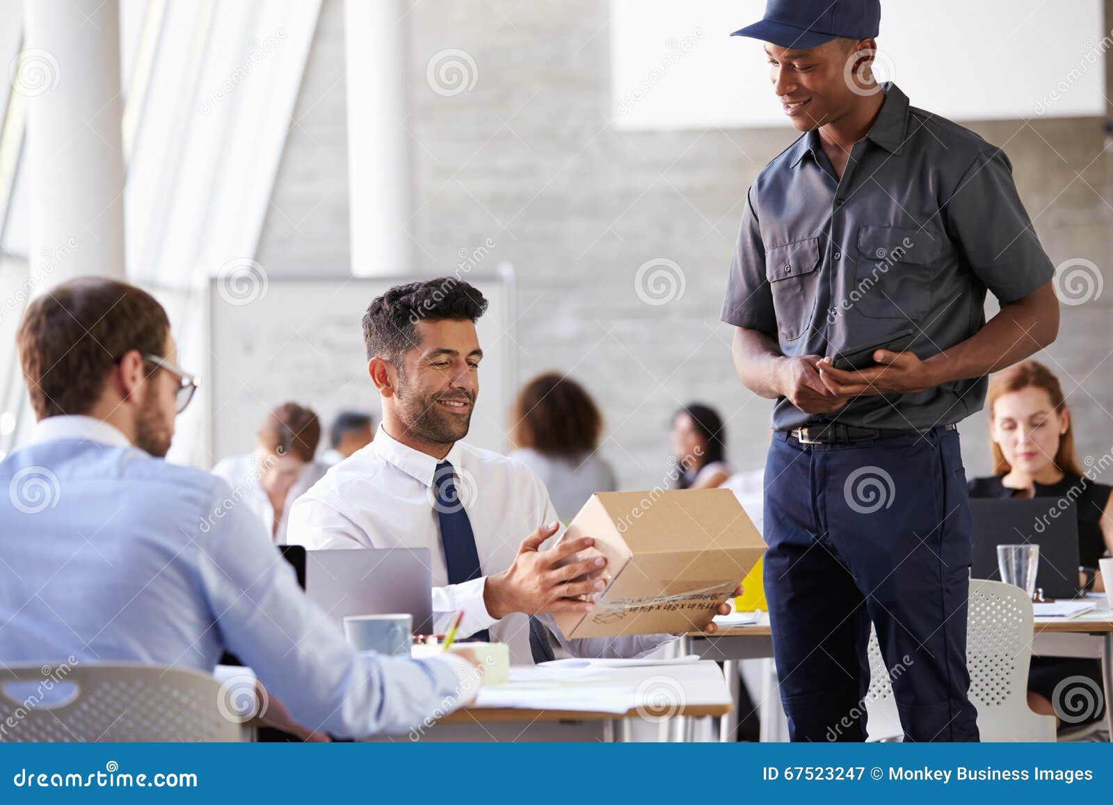 Courier Delivering Package To Businessman in Busy Office Stock Image ...