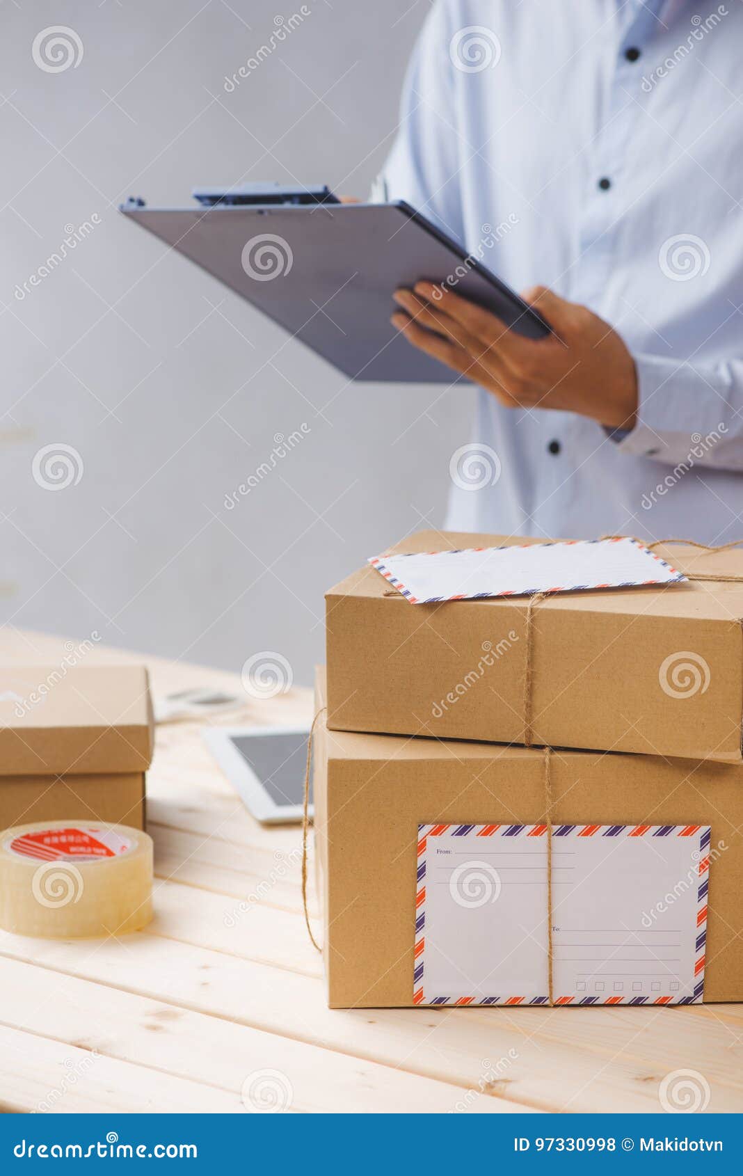 Courier Making Notes in Delivery Receipt among Parcels at Table Stock ...