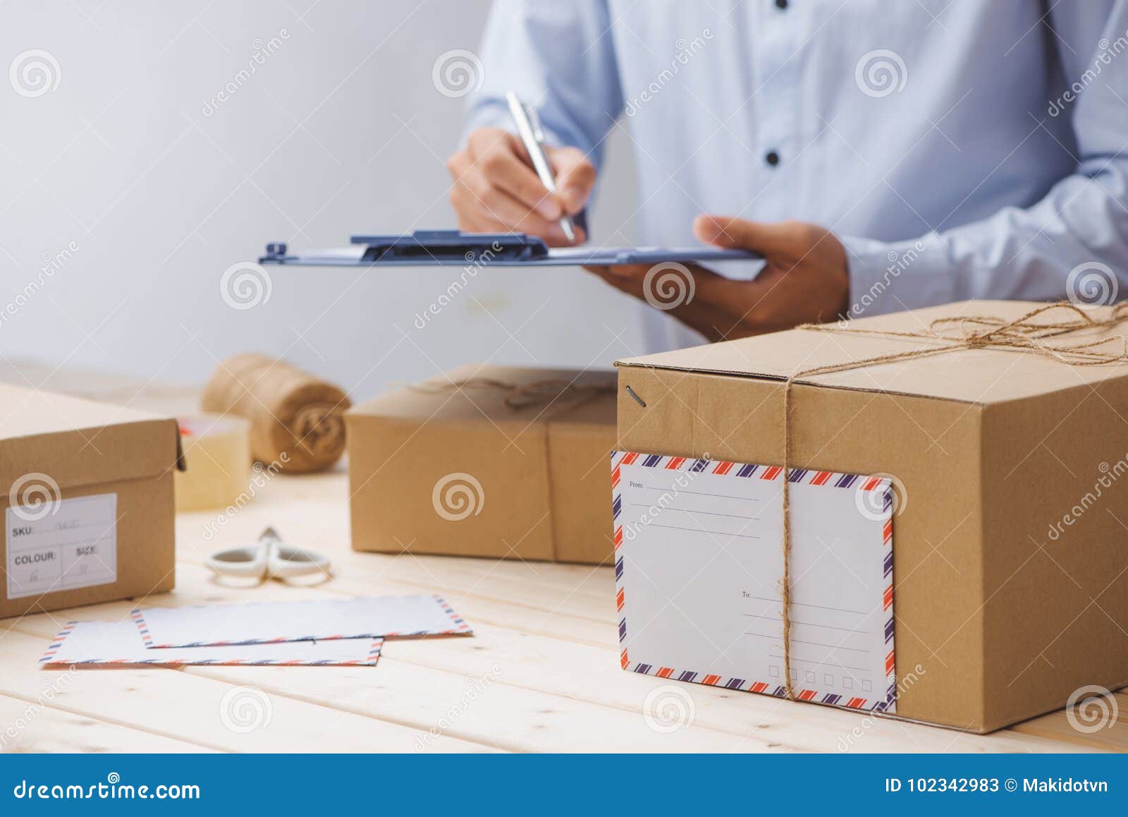 Courier Making Notes in Delivery Receipt among Parcels at Table Stock ...