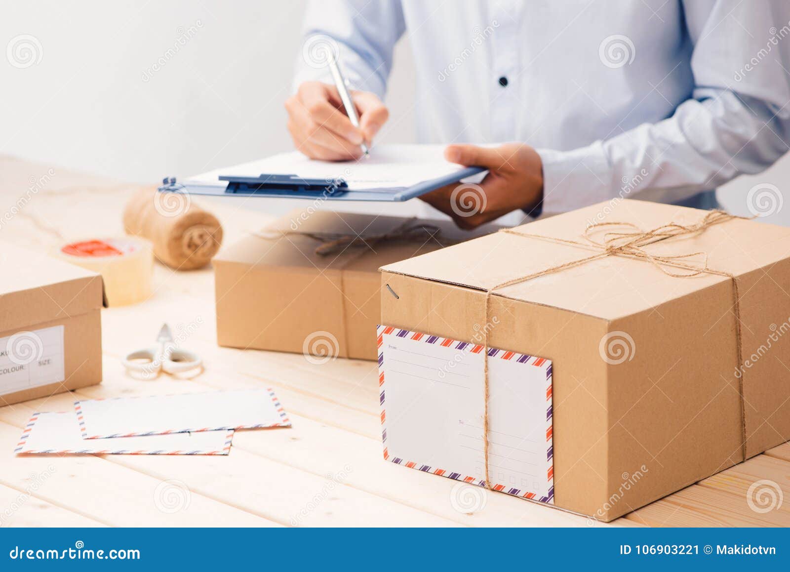 Courier Making Notes in Delivery Receipt among Parcels at Table Stock ...