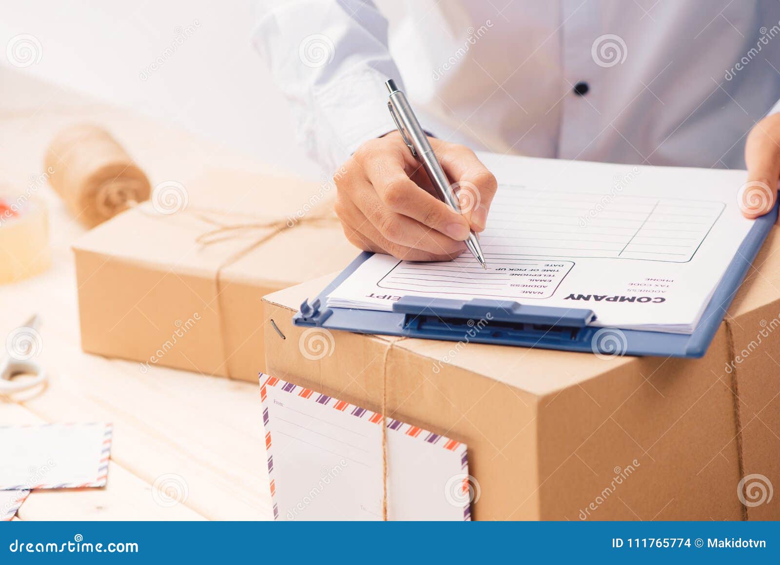 Courier Making Notes in Delivery Receipt among Parcels at Table Stock ...