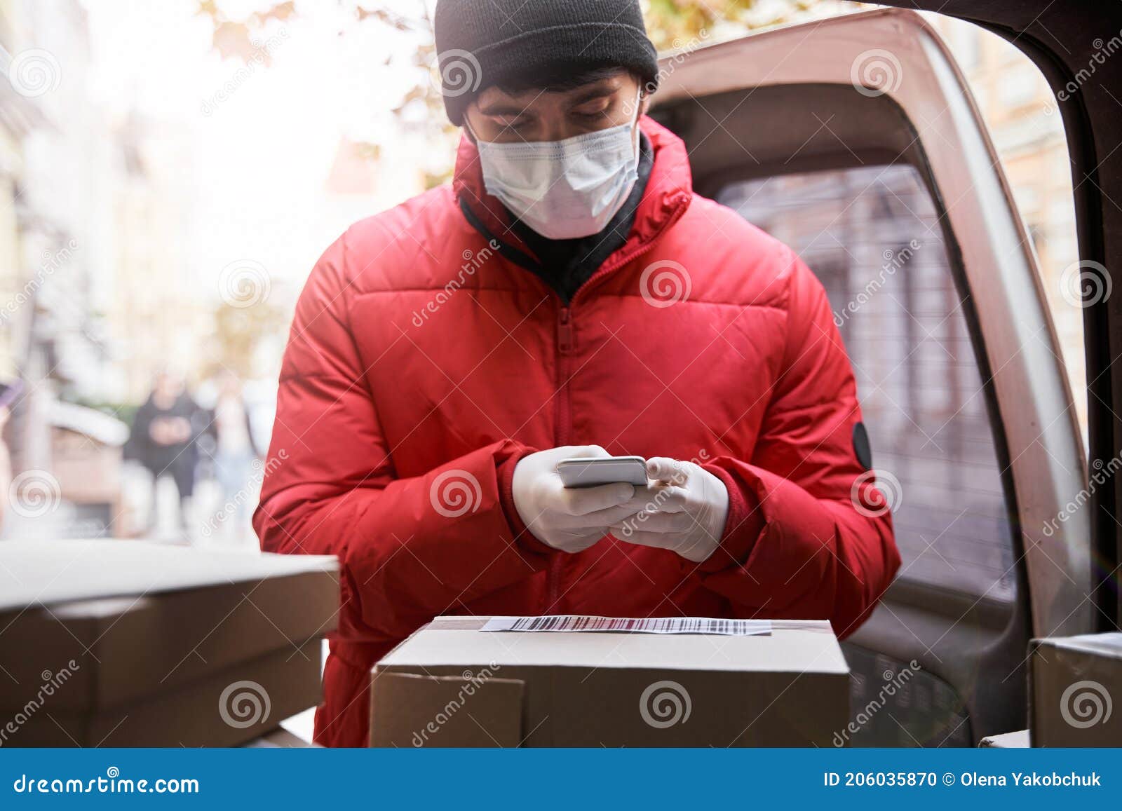 Courier in Mask Holding Smartphone while Scanning a Barcode Stock Photo ...