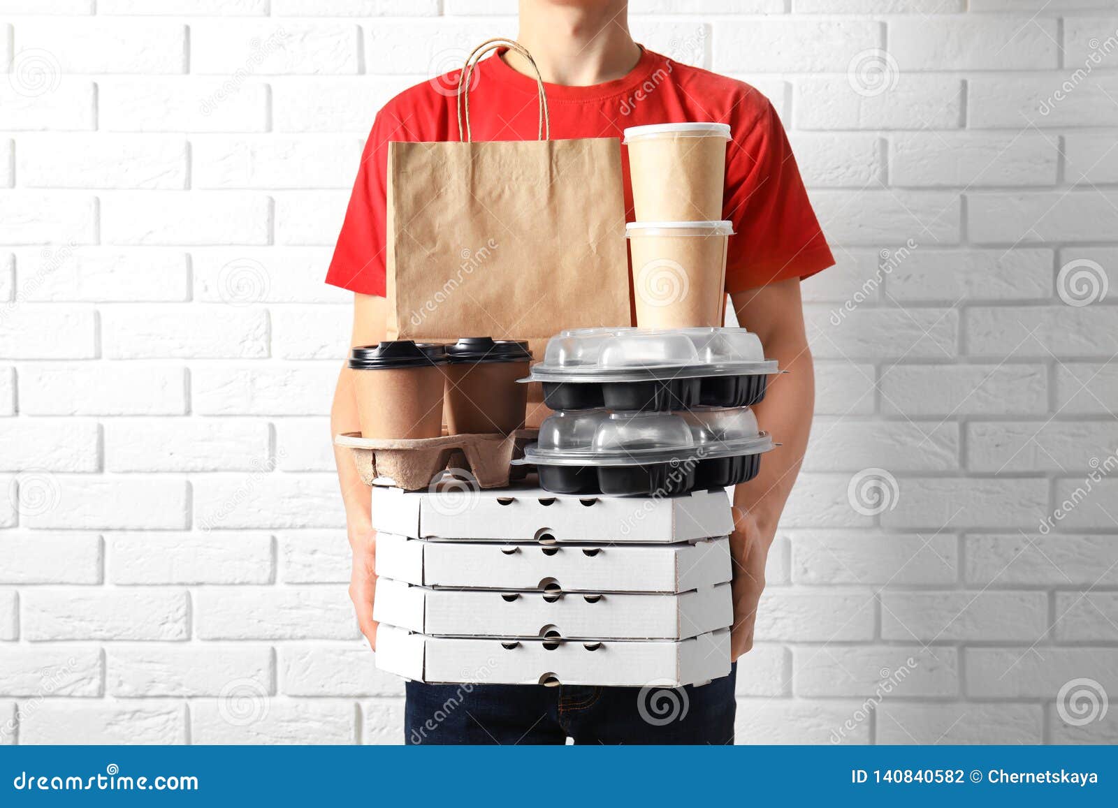 Courier with Stack of Orders Near White Brick Wall. Stock Photo - Image ...