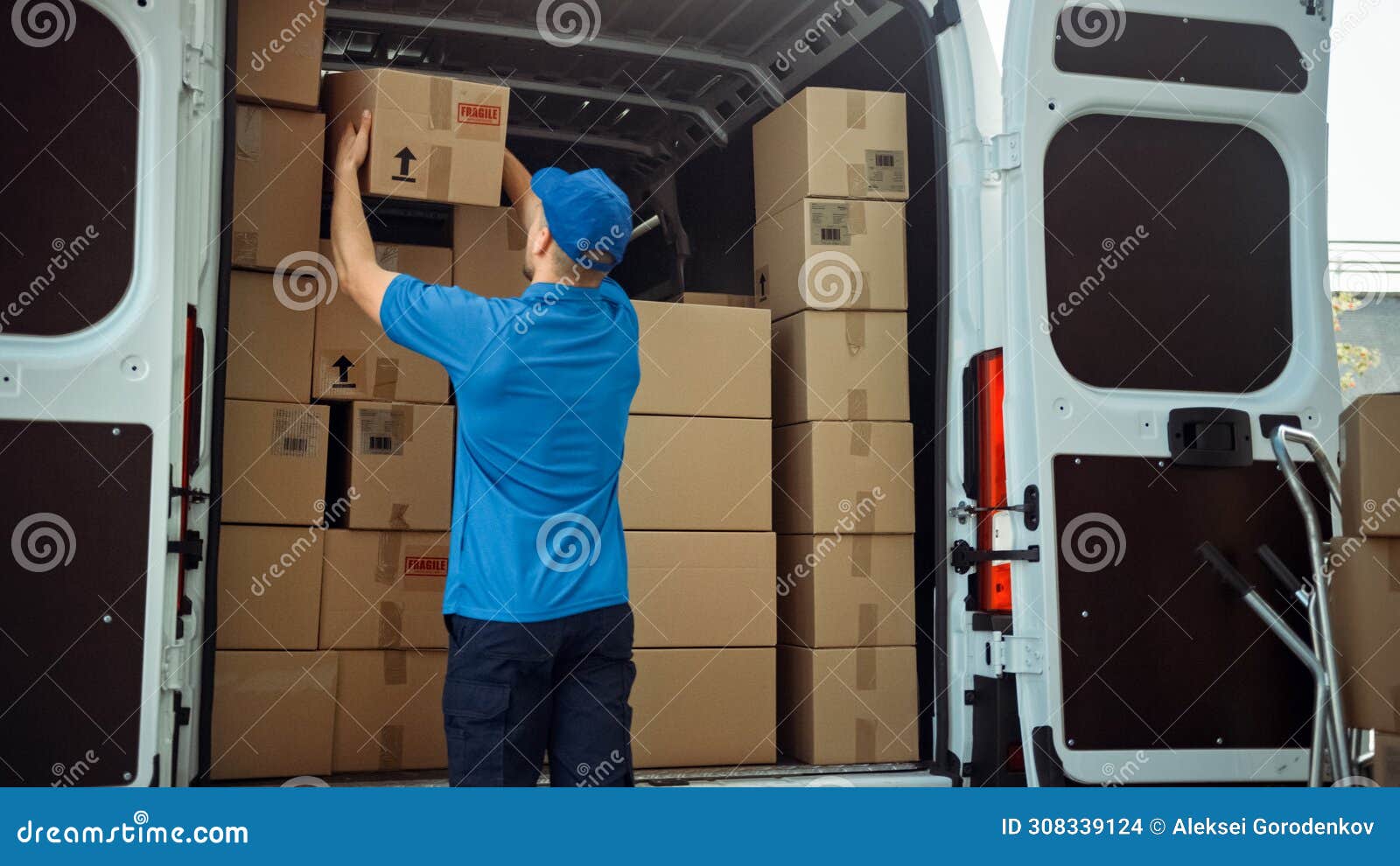 Courier Takes Out Cardboard Box Package from Delivery Van Full of ...