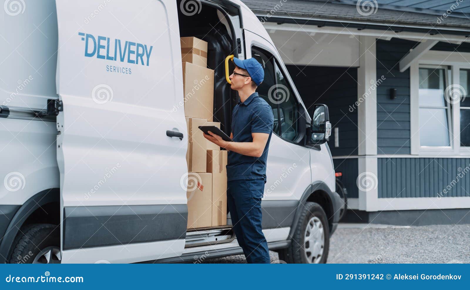 Courier Using Tablet Computer Next To Open Delivery Van Side Door with ...