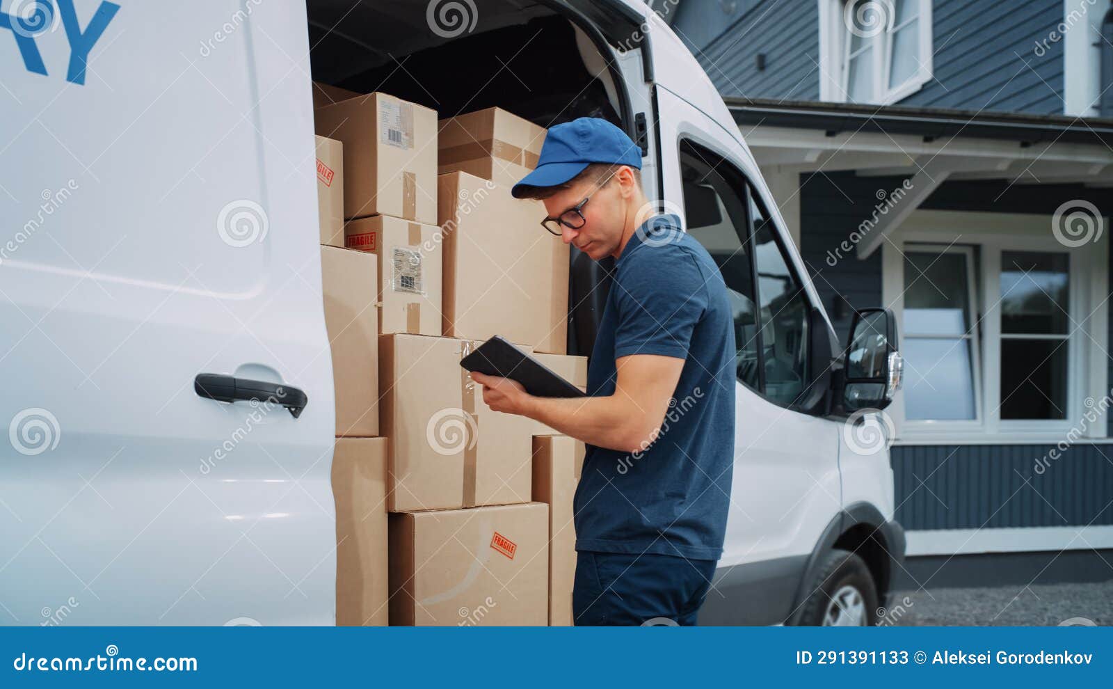 Courier Using Tablet Computer Next To Open Delivery Van Side Door with ...