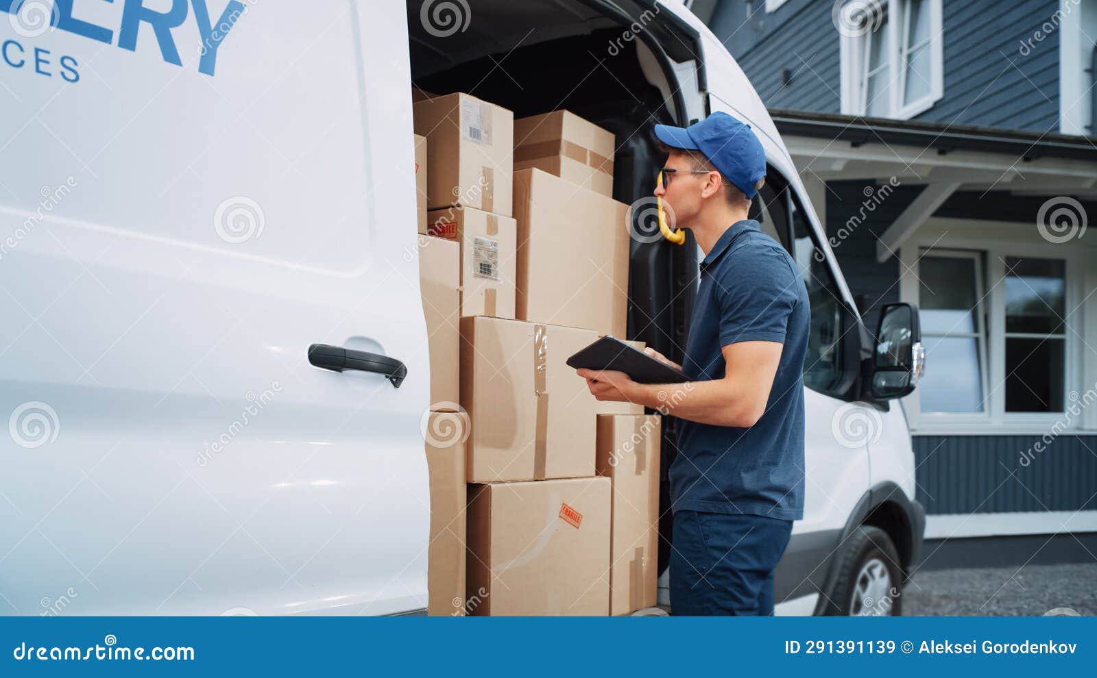 Courier Using Tablet Computer Next To Open Delivery Van Side Door with ...