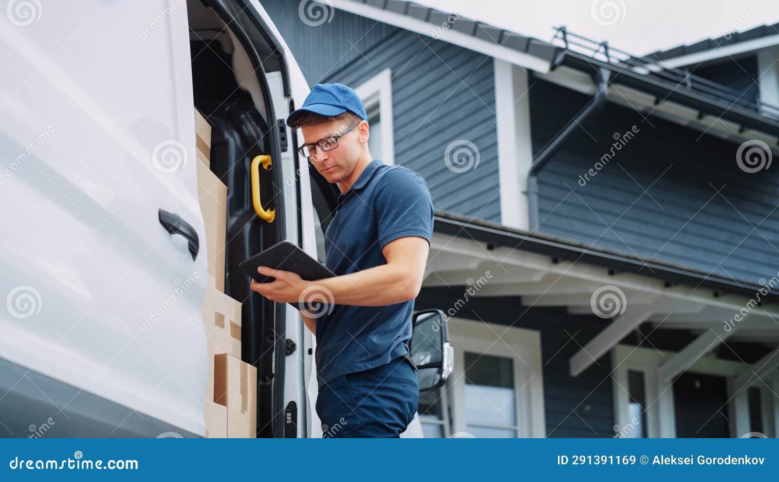Courier Using Tablet Computer Next To Open Delivery Van Side Door with ...