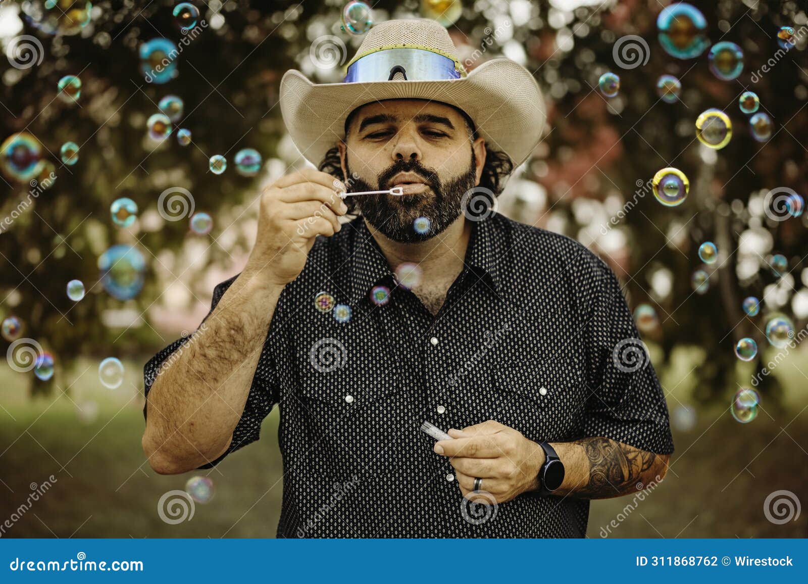 Cowboy Blowing Bubbles in a Park Stock Photo - Image of traditional ...