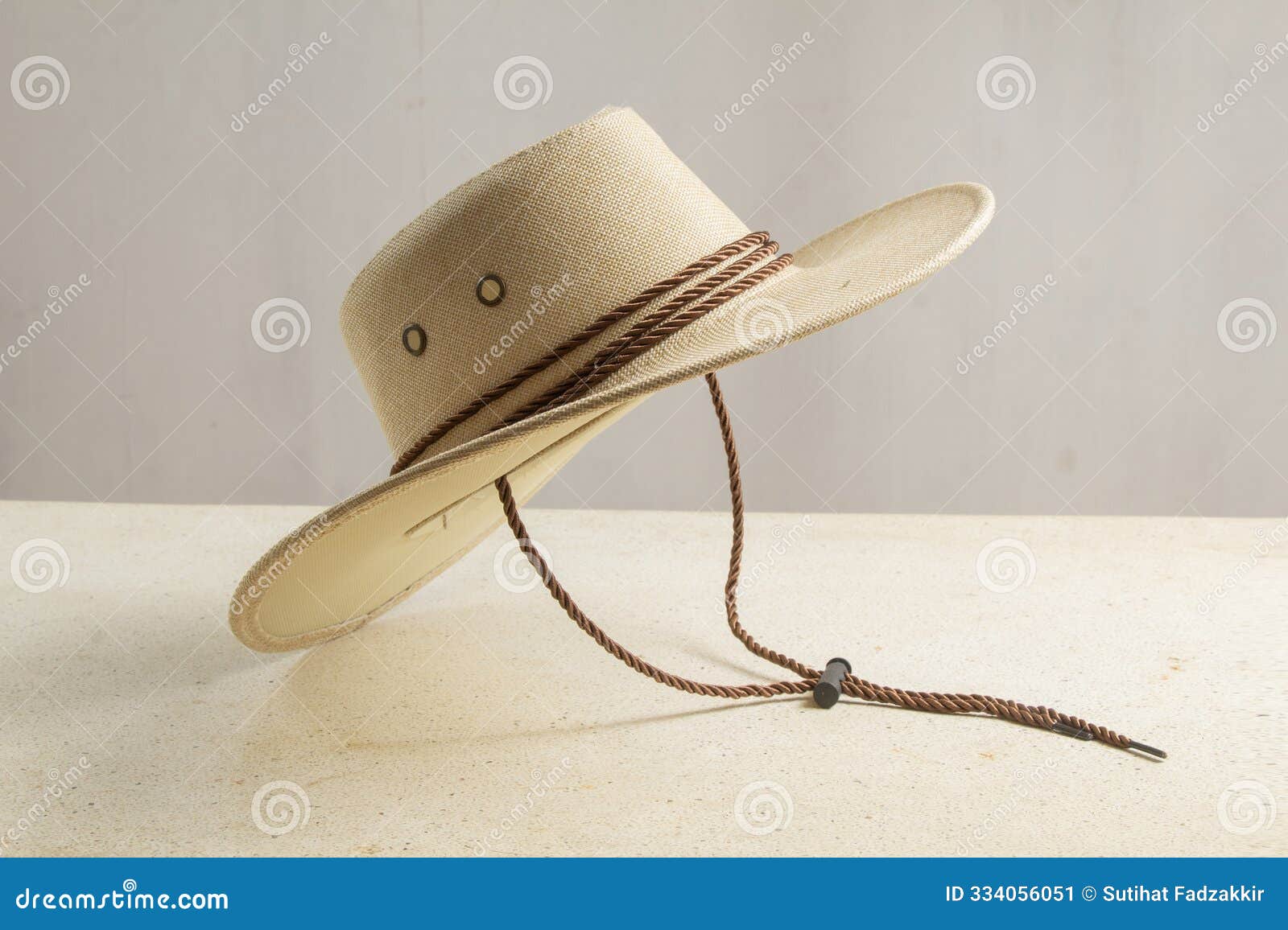A Cowboy Hat with a Brown Ribbon Tied To the String on Top of the Hat ...