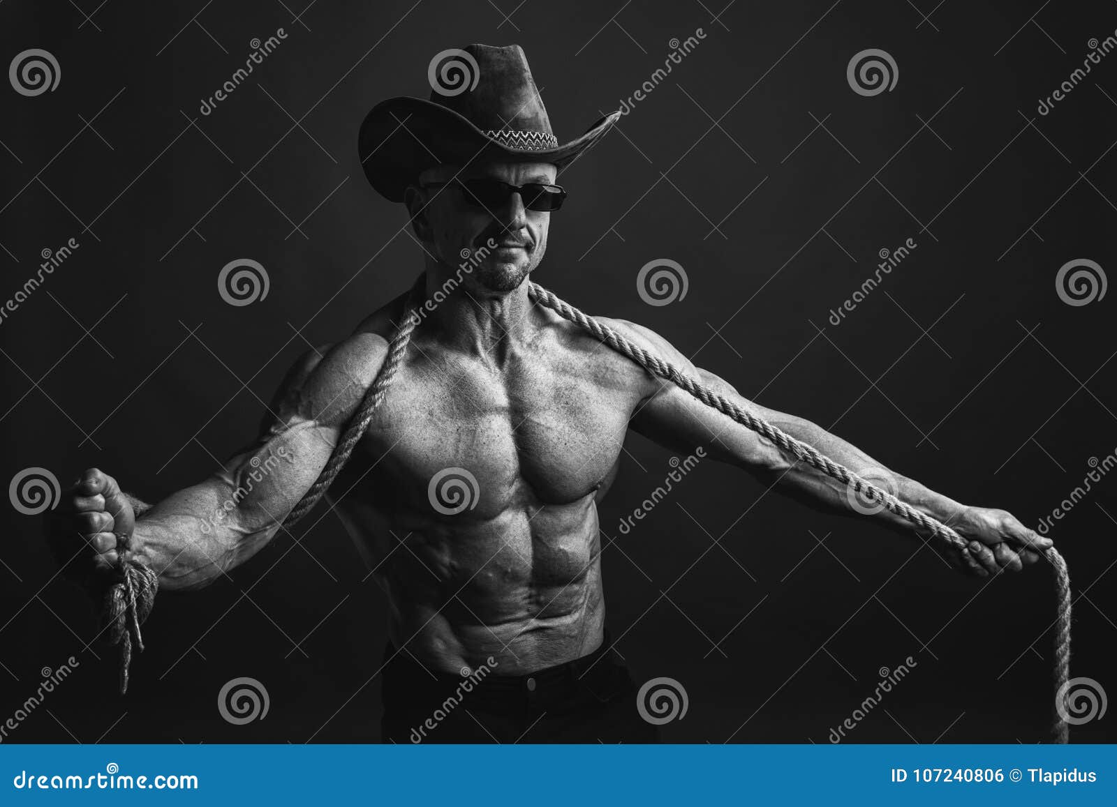A Cowboy in His Hat and Sunglasses with a Rope on His Shoulder. Stock ...