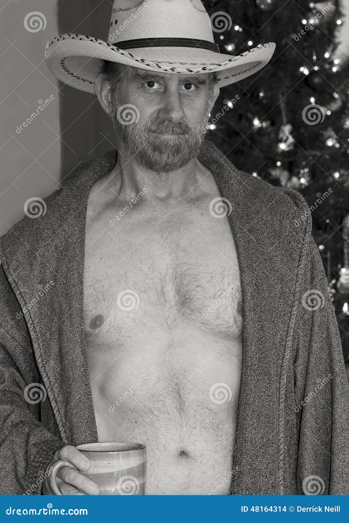 A Cowboy in an Open Robe by a Christmas Tree Stock Photo - Image of ...