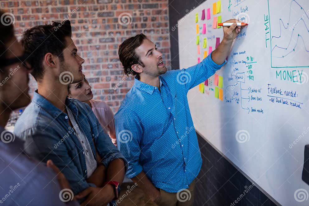 Coworkers Interacting Front of a Board Stock Photo - Image of ...