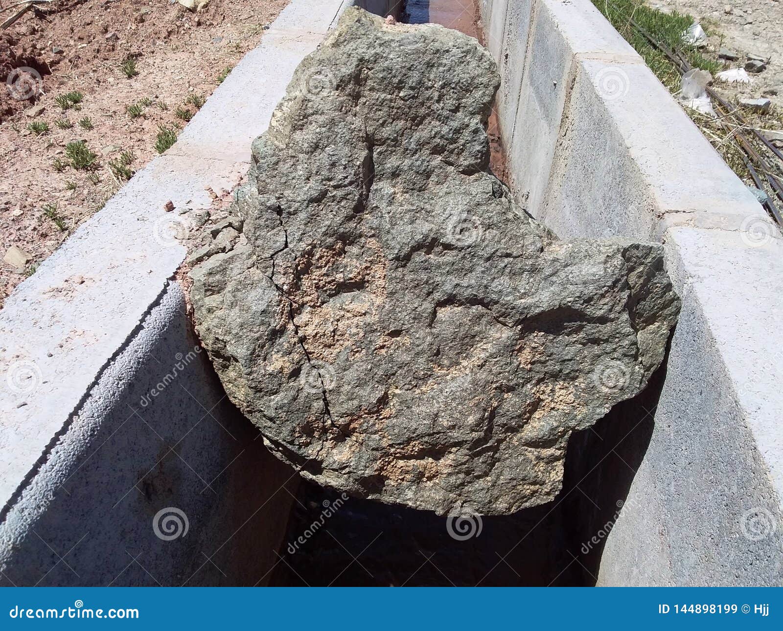 Cracked Green Rock Stranded by Two Concrete Block Stock Image - Image ...