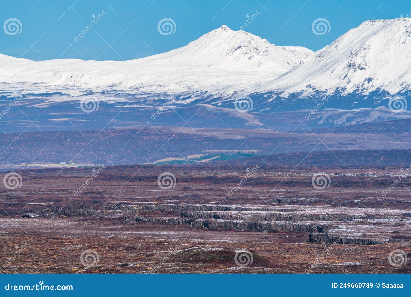 Cracked Ground and Snow Covered Mountains in the Background Stock Image ...
