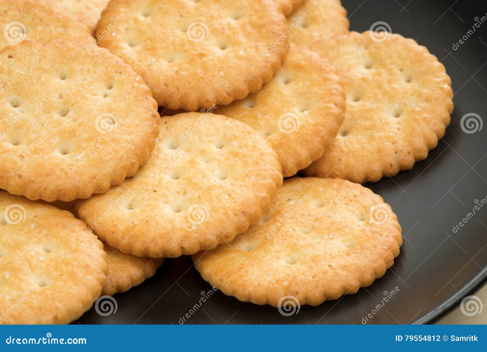 Crackers in Black Plate on Wood Table Stock Photo - Image of bread ...