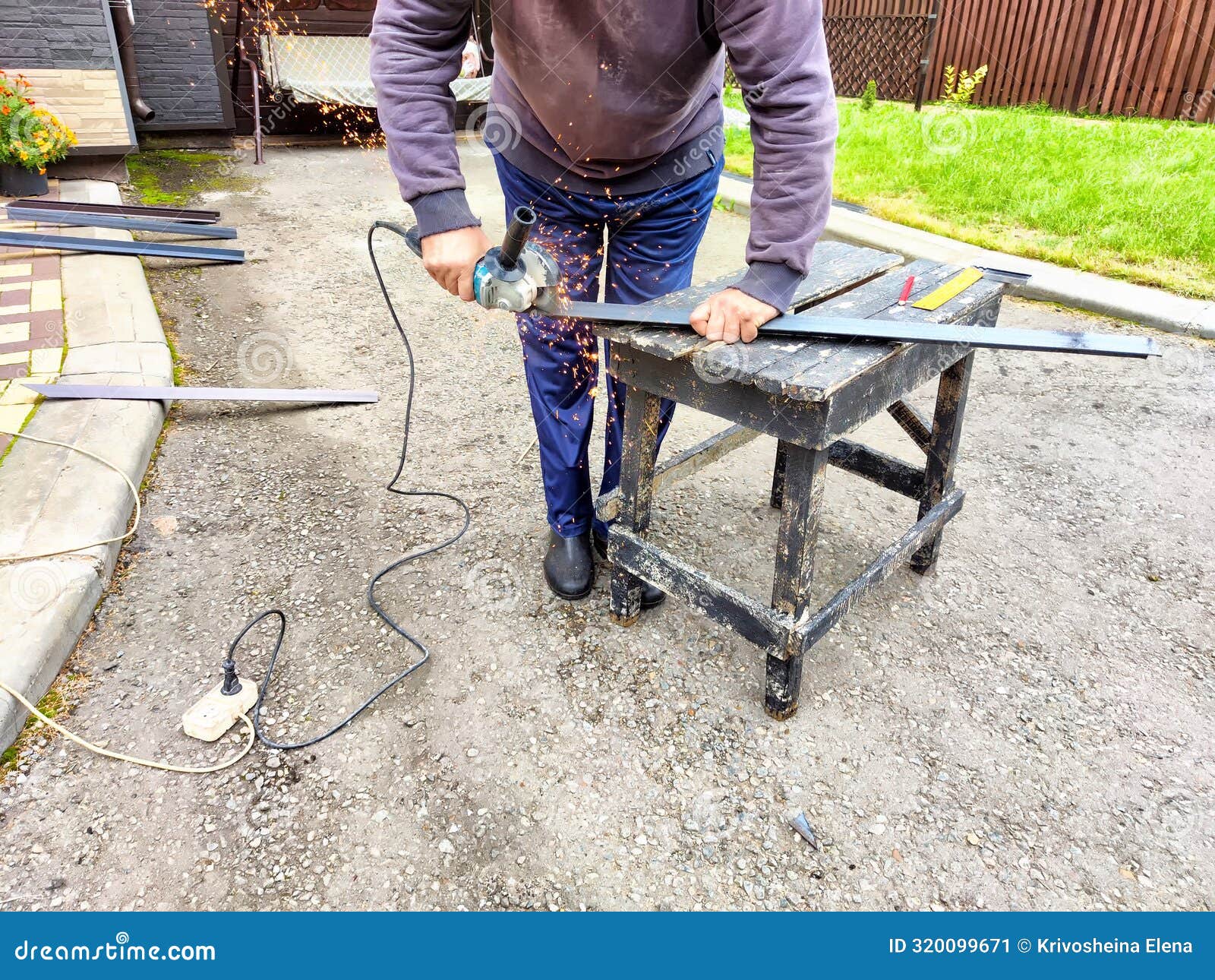 Craftsman Cutting Metal Column with Grinder Outdoors. Man Using a ...