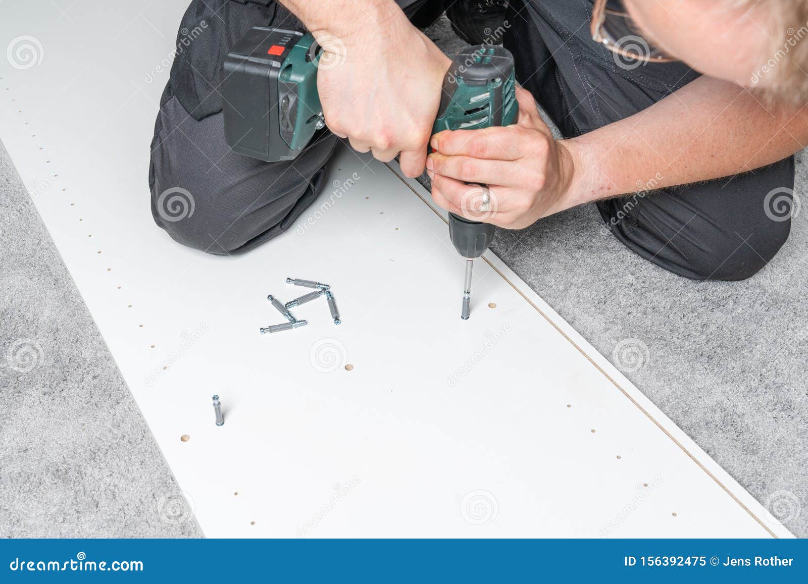 A Craftsman Screws a Cupboard with an Screwdriver Together Stock Image ...