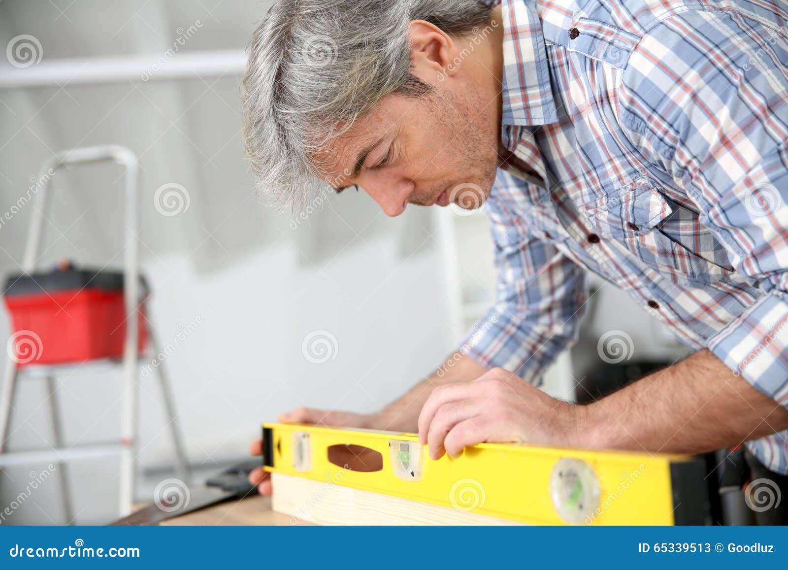Craftsman using level stock image. Image of renovation - 65339513
