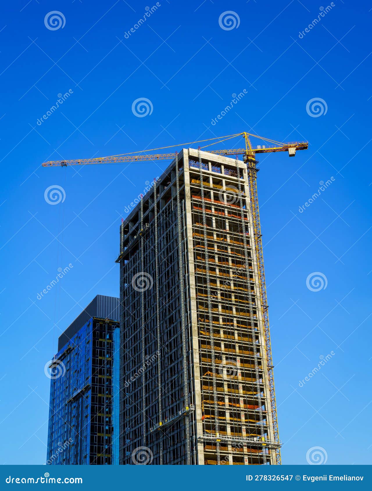A Crane Building a Modern Skyscraper Against a Blue Sky. Construction ...