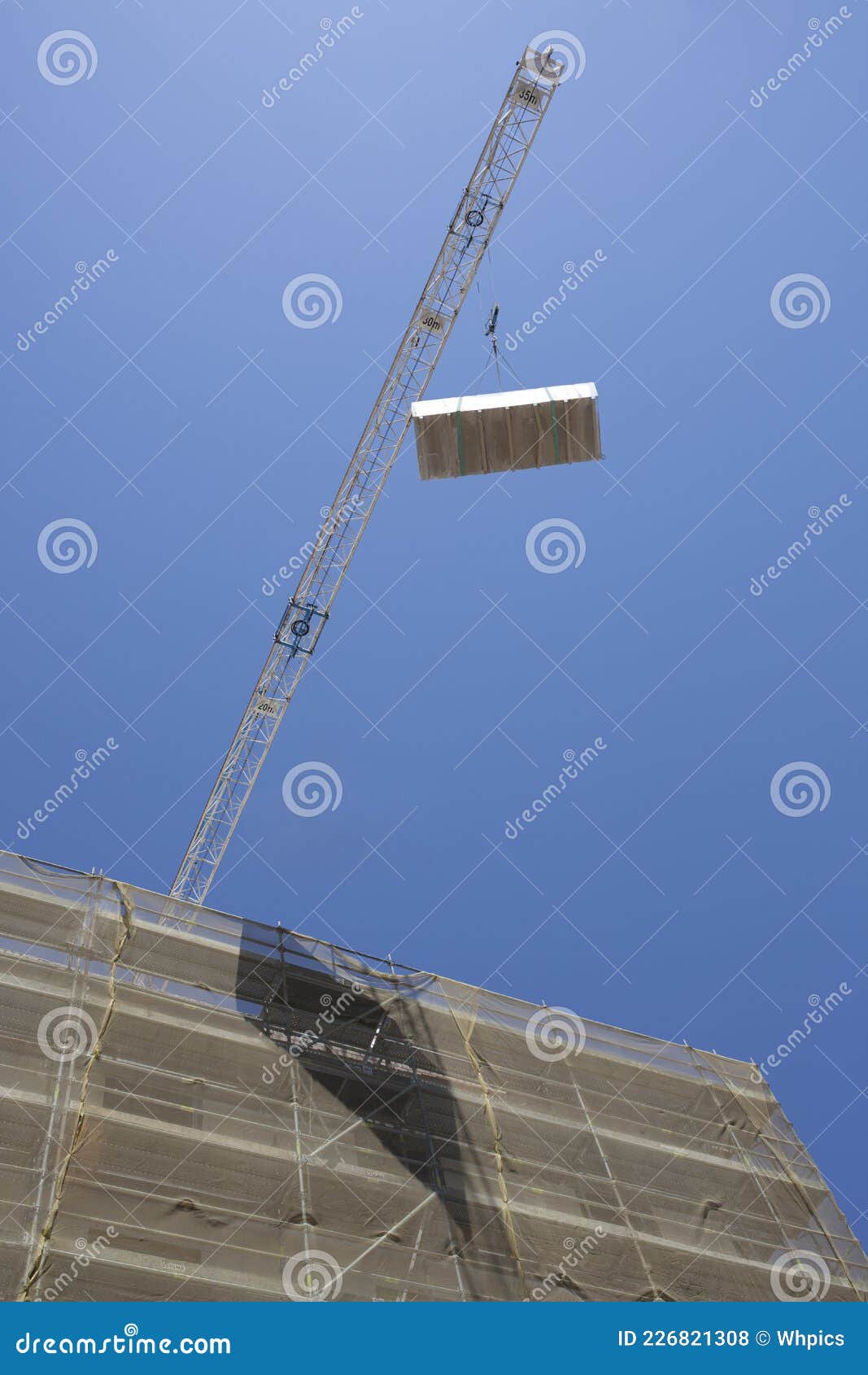 Crane with Load of Drywall Panels Over Construction Site Stock Photo ...