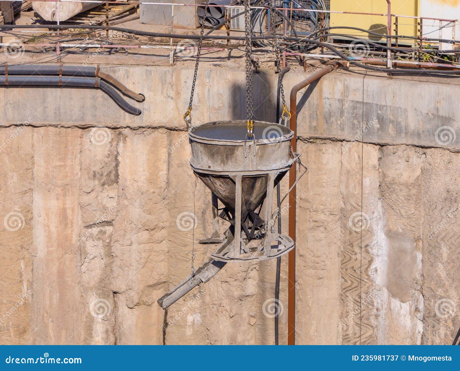 The Crane Lowers a Container with Concrete Mortar into a Huge Pit ...