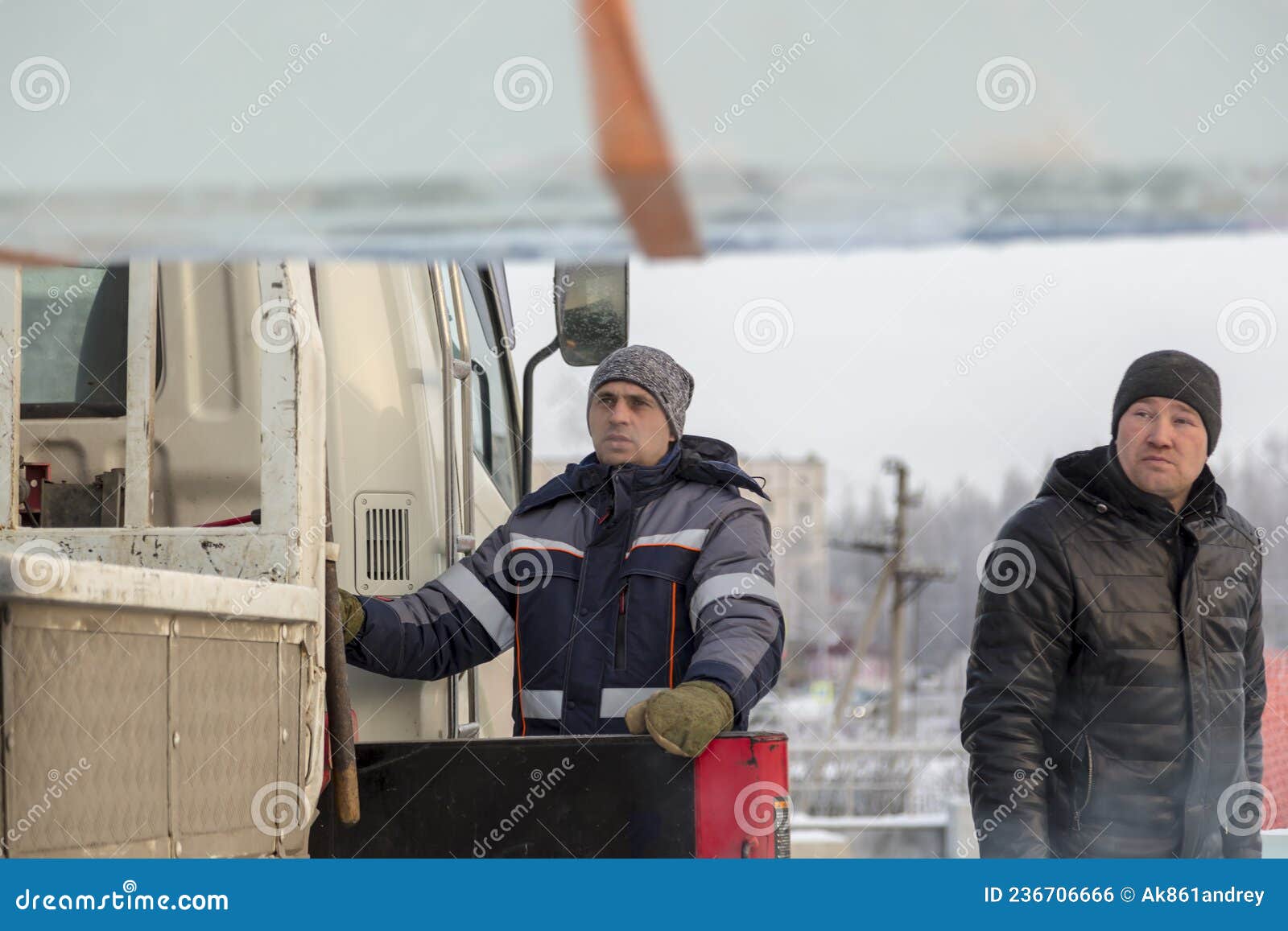 Crane Operator in Blue Jacket and Gray Hat Unloading Ice Blocks Stock ...