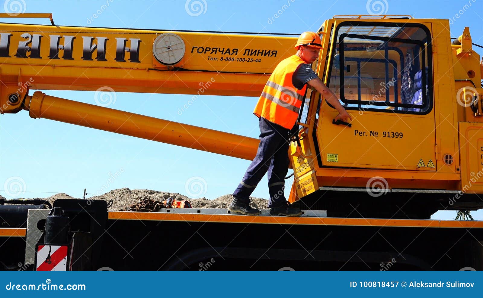 The Crane Operator in the Helmet Sits in the Control Cab of the Car ...