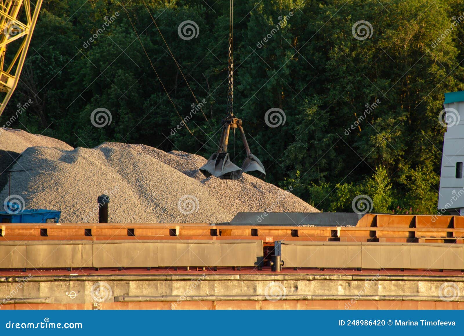 A Crane in the Port Unloads Crushed Granite. Bulk Cargo Import Concept ...