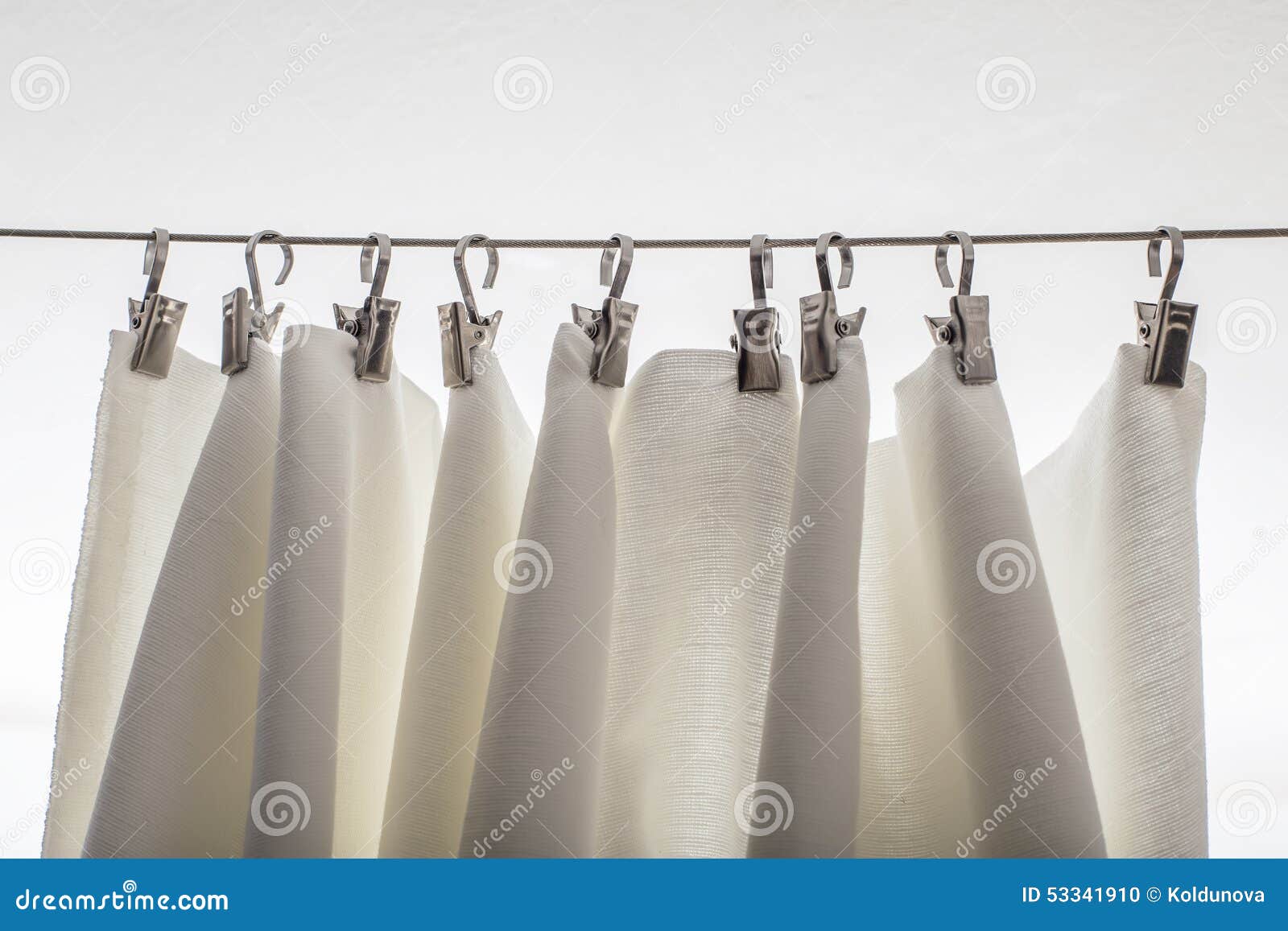 Cream-colored Curtain Hanging on a String on Metal Hooks Stock Photo ...