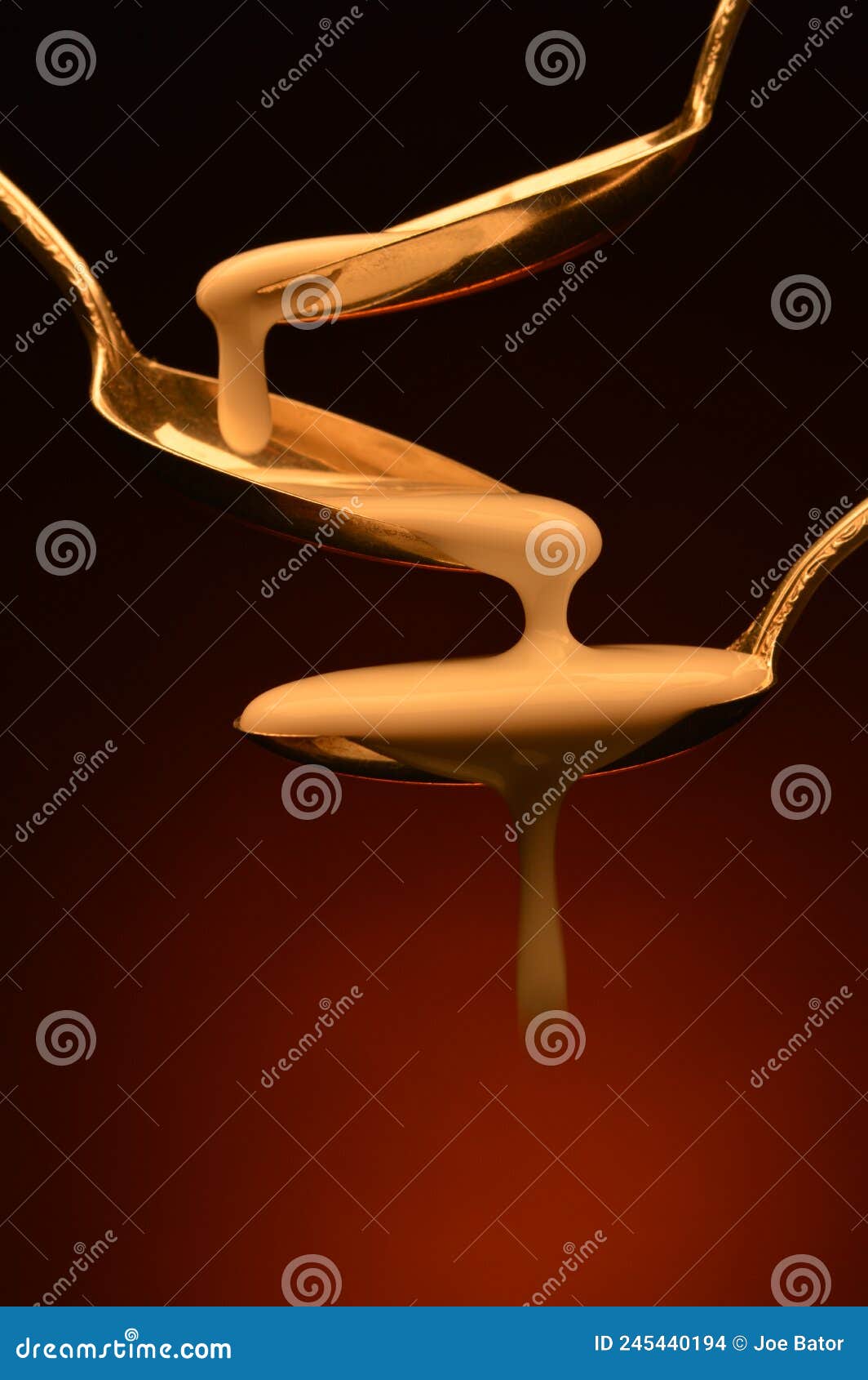 Cream Pouring from One Spoon into Another Stock Photo - Image of three ...