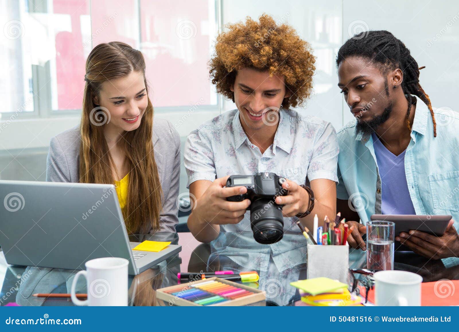 Creative Business People Looking at Digital Camera at Desk Stock Photo ...