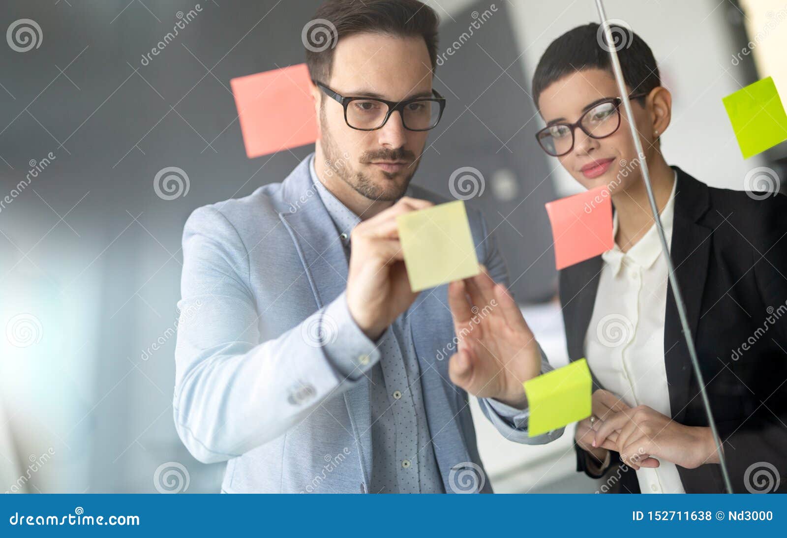 Creative Business Team Looking at Sticky Notes on Window Stock Photo ...
